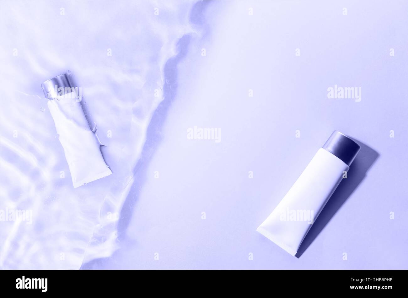 Tube of sunscreen on water surface. Cosmetic cream lotion, sunscreen on ...