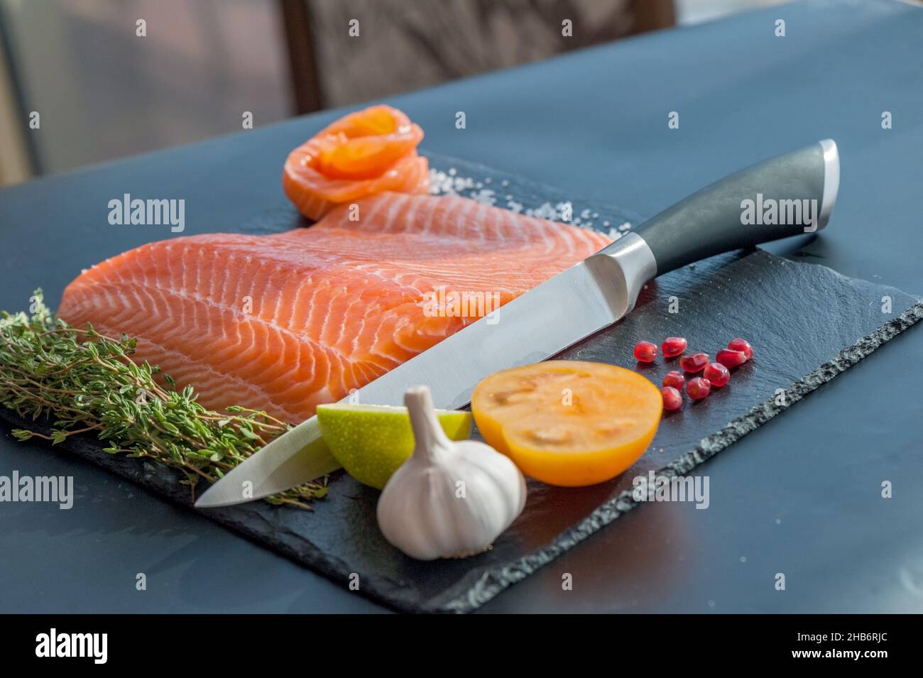 Hand chef using knife slice raw salmon on chopping block. Salmon fillet ...