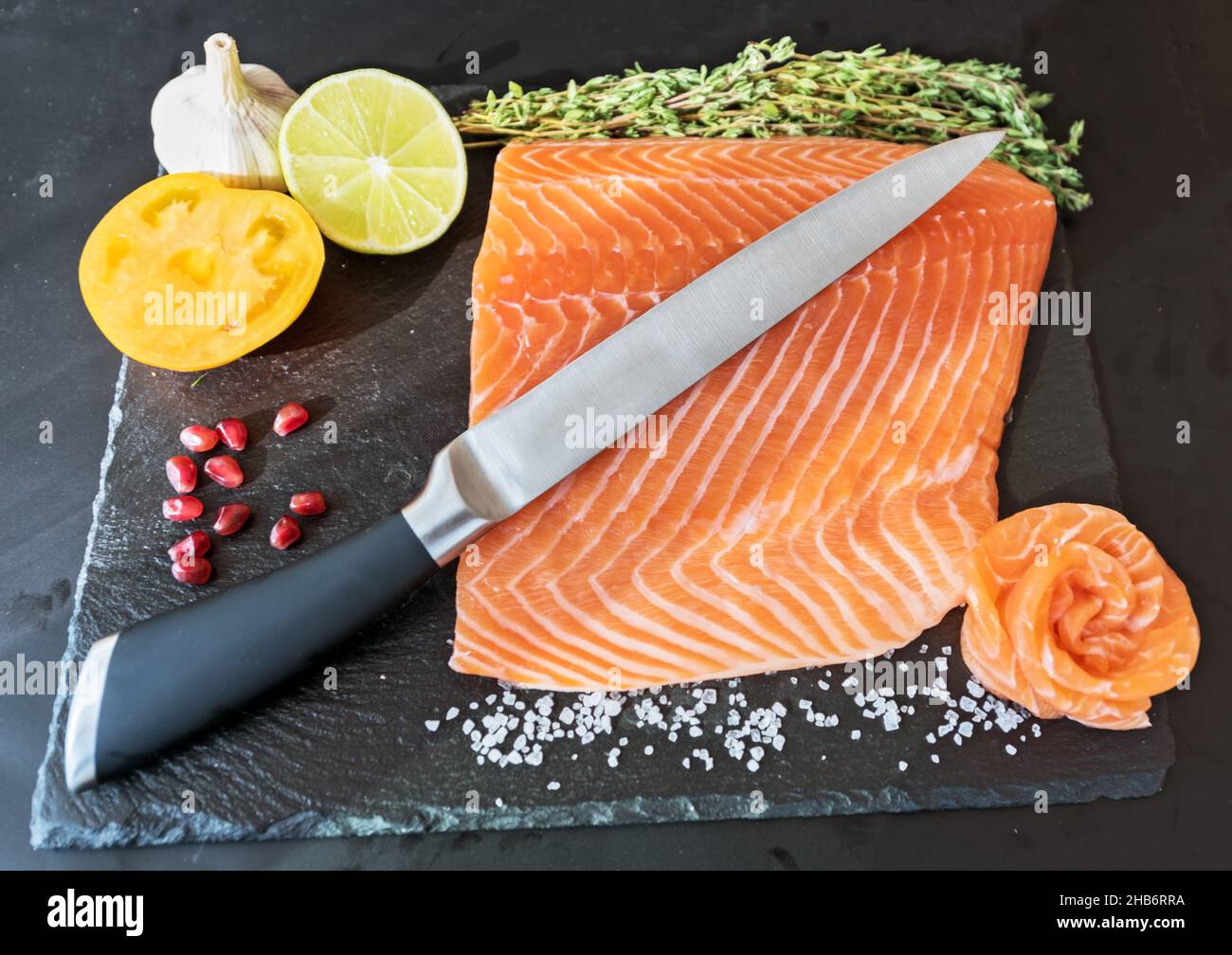 Hand chef using knife slice raw salmon on chopping block. Salmon fillet ...