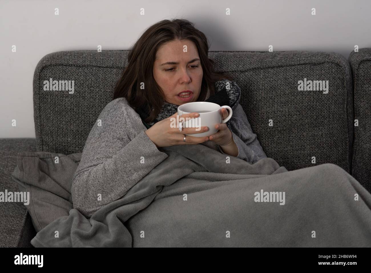 sick young girl lying on the sofa at home Stock Photo - Alamy