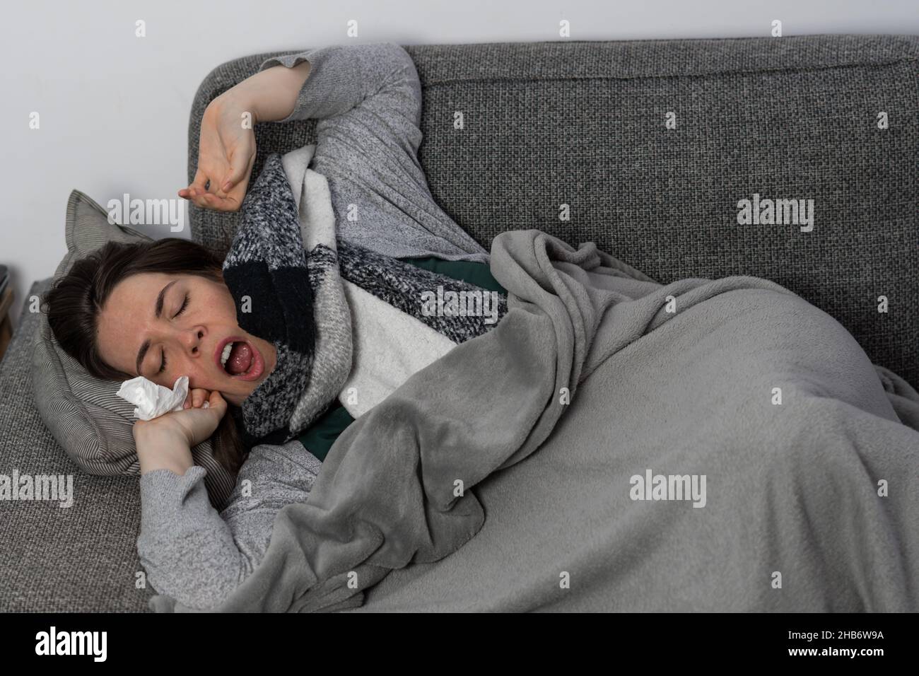 sick young girl lying on the sofa at home Stock Photo - Alamy