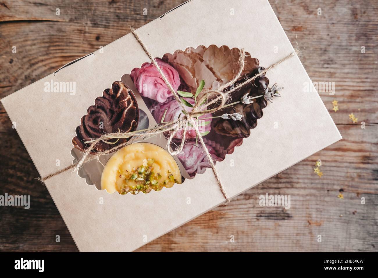 closed box with different cakes wrapped with thread, on a wooden ...