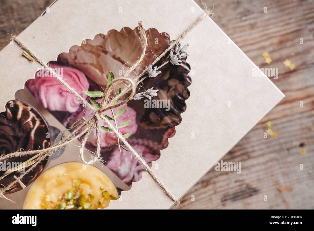 closed box with different cakes wrapped with thread, on a wooden ...