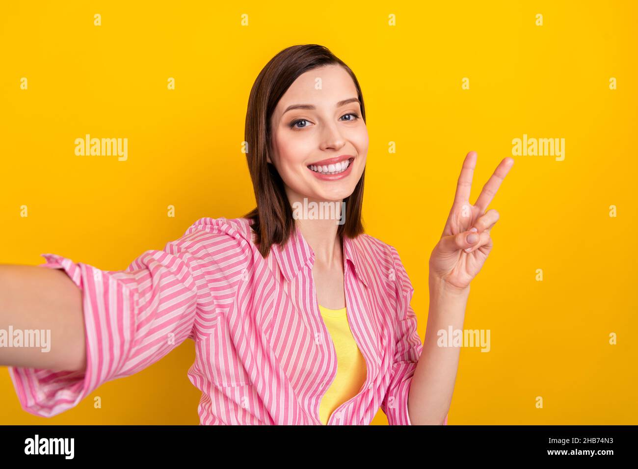 Portrait of cheerful pretty girl take selfie fingers make v-sign hello ...