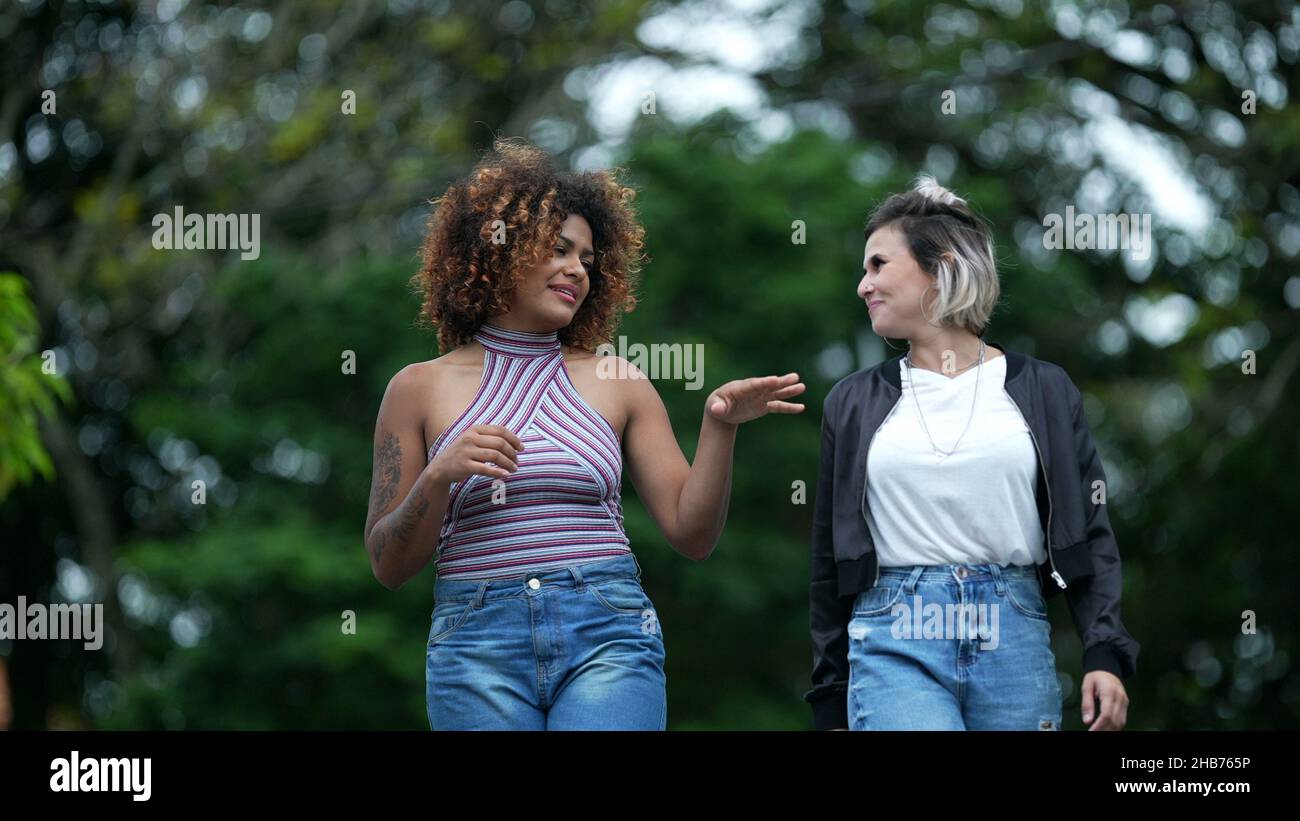 Two Brazilian friends hanging together outside in street. diverse ...