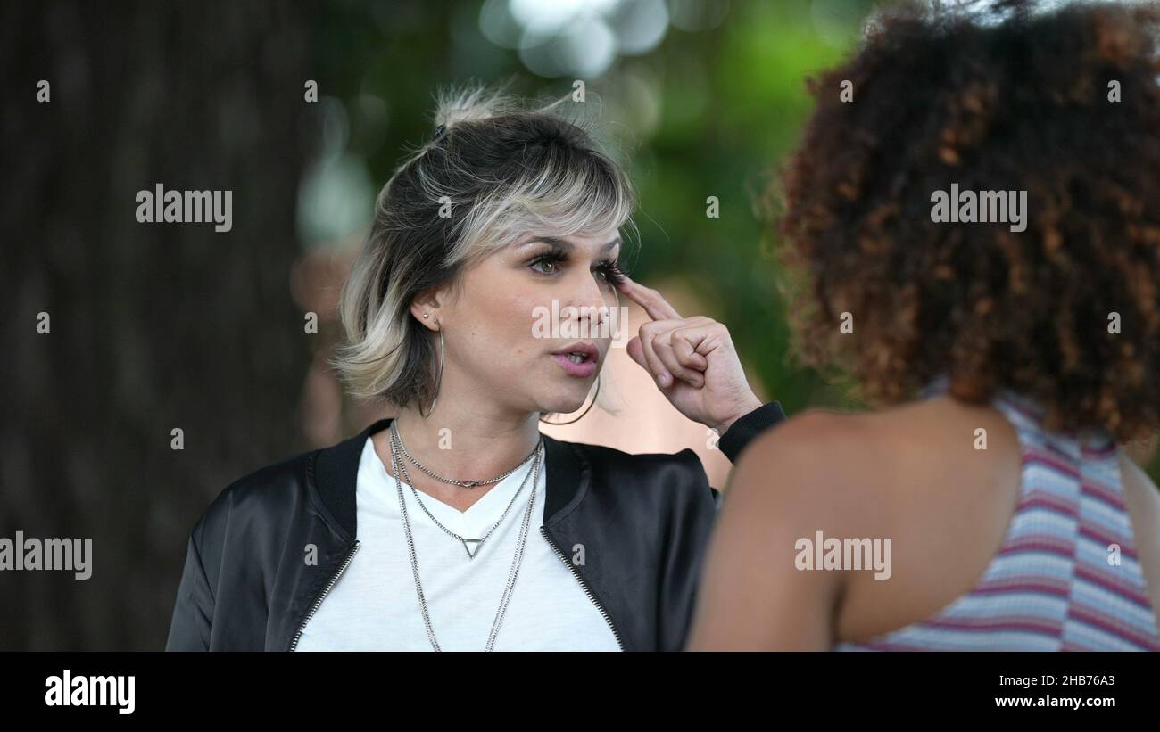 Two diverse friends talking outside at park. people conversation Stock ...