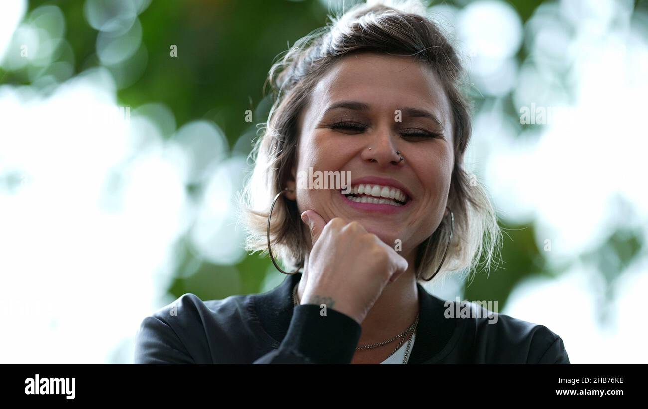 Woman spontaneous real life laugh and smile outside. Person bursts ...