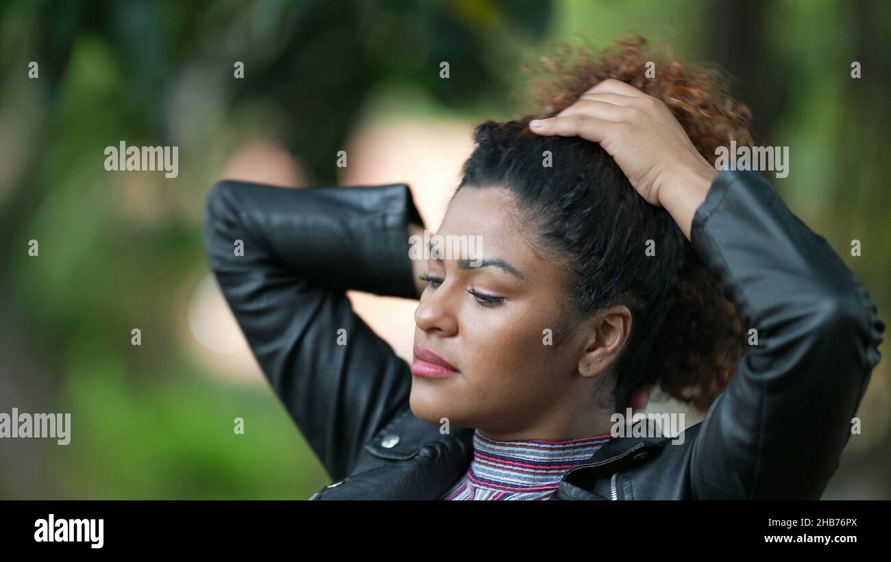 Woman tying hair outside, Brazilian girl ties hair Stock Photo - Alamy