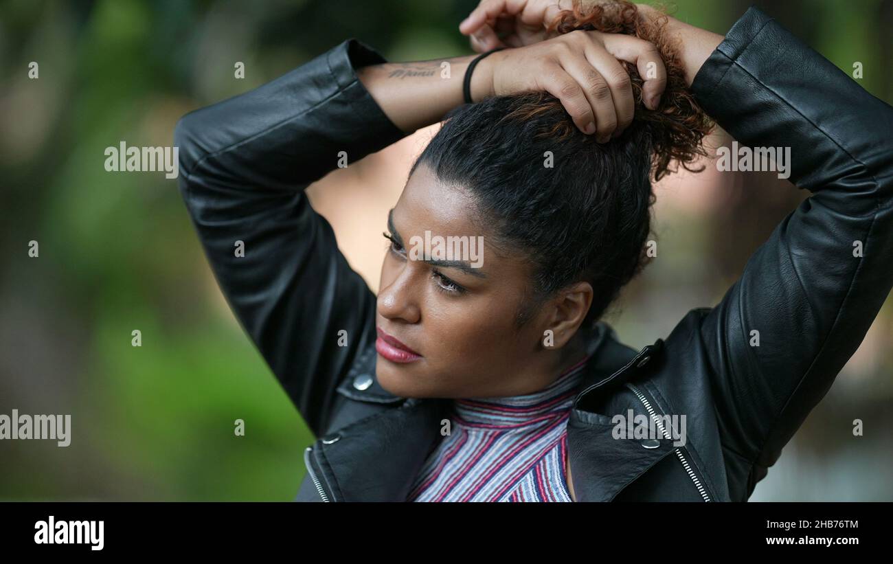 Woman tying hair outside, Brazilian girl ties hair Stock Photo - Alamy