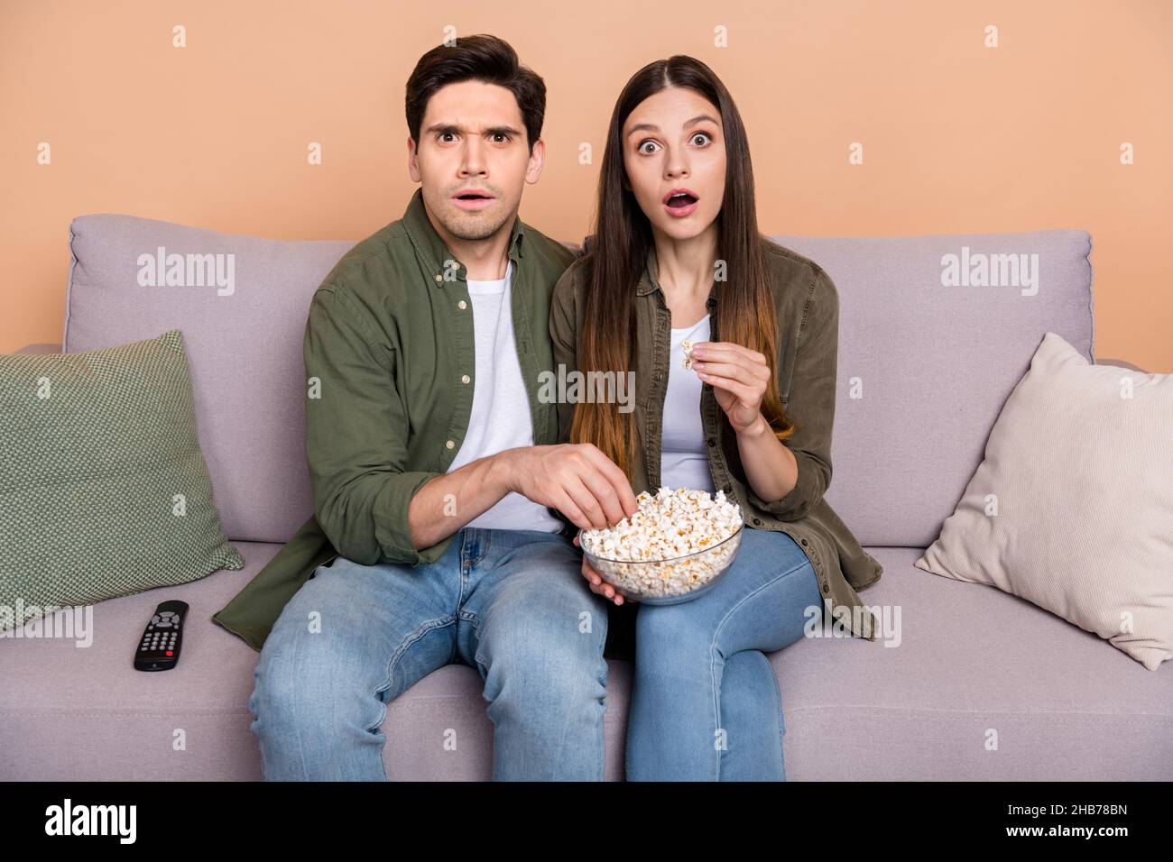 Photo of stupor guy lady fellows sit couch watch horror series eat pop ...