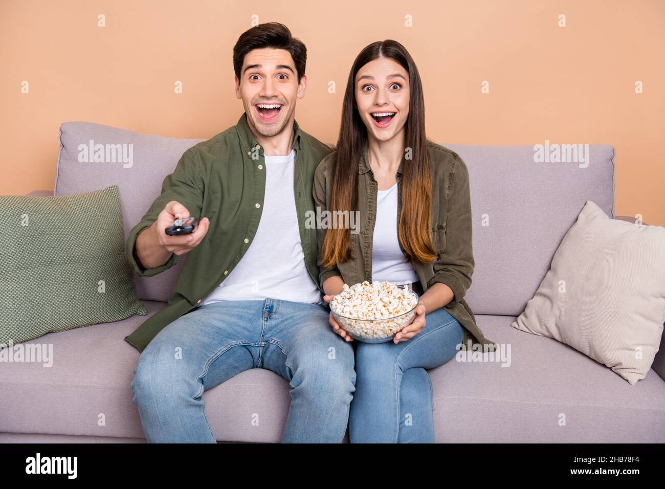 Photo of impressed spouses sit divan hold popcorn watch series remote ...