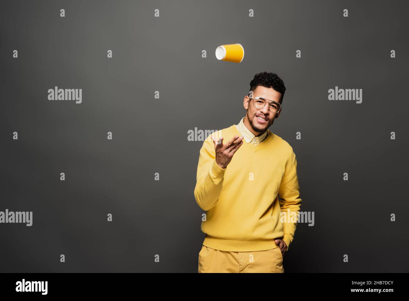 cheerful african american man in glasses throwing empty paper cup on ...