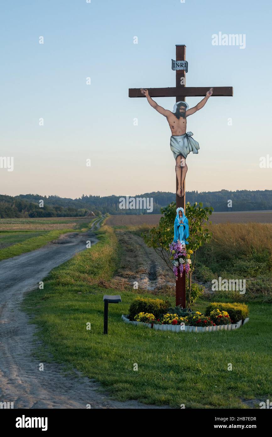Vertical shot of a wooden cross with the picture of Jesus Christ in a ...