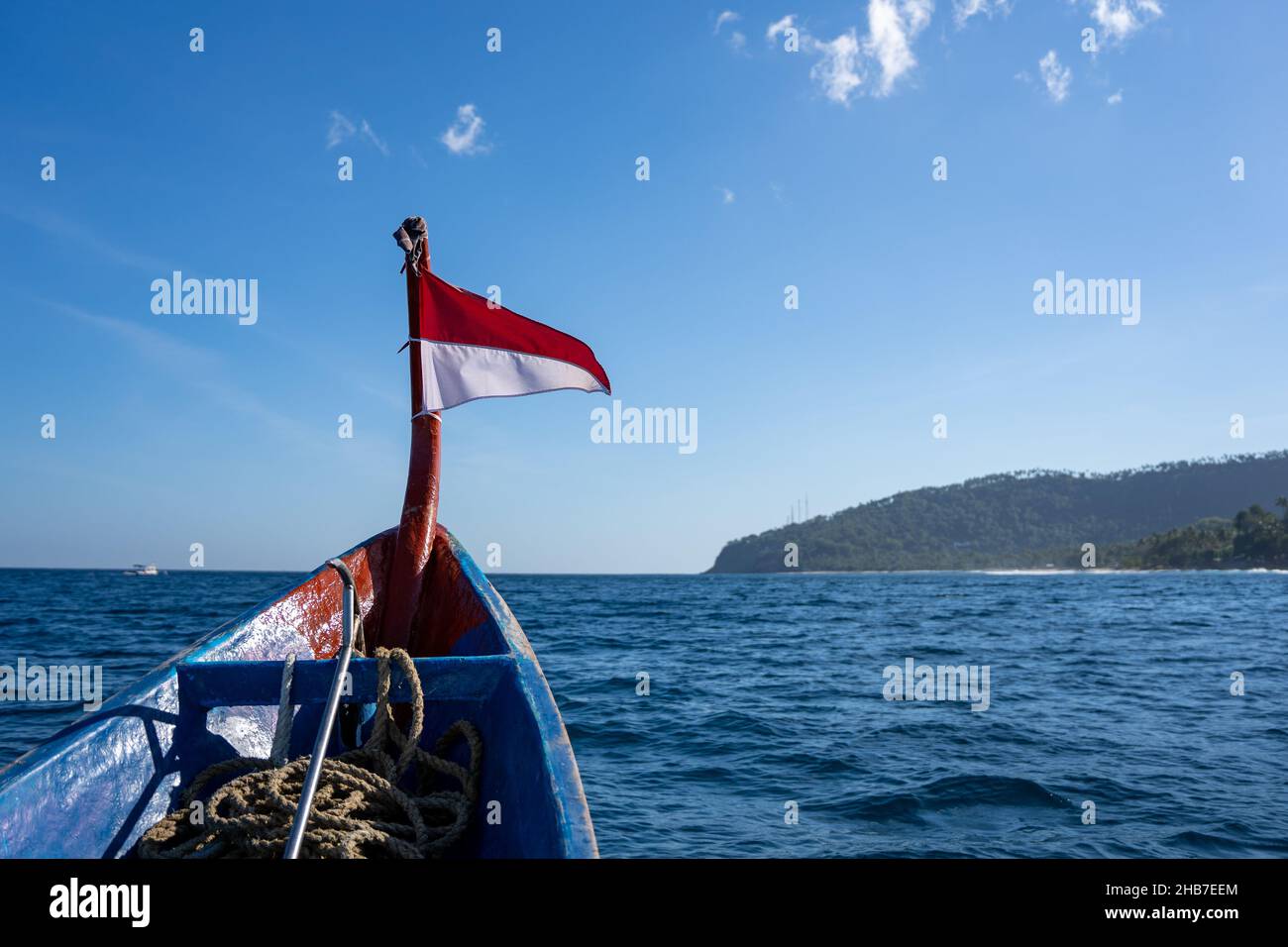 Old, wooden boat with a red and white flag sailing in the ocean Stock ...