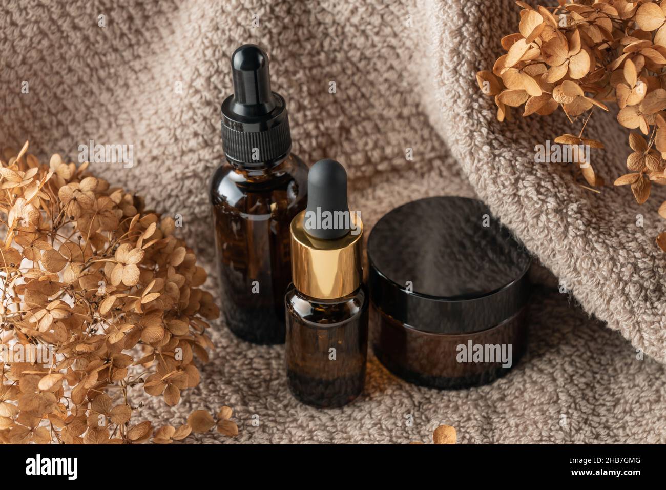 Set of amber glass cosmetic bottles on brown background. Natural ...