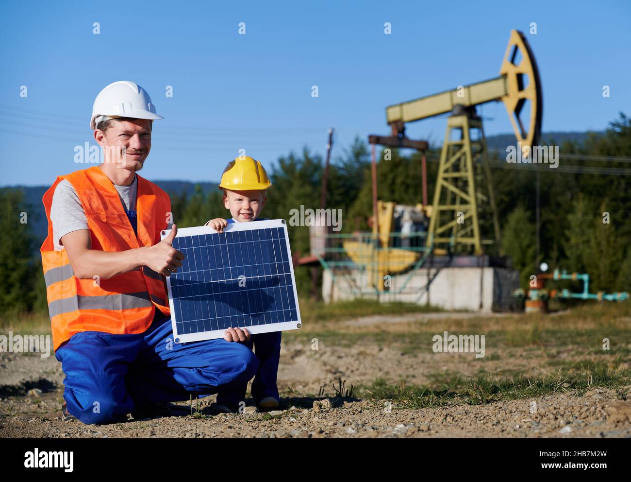 Cheerful oil man and child looking at camera and smiling while holding ...