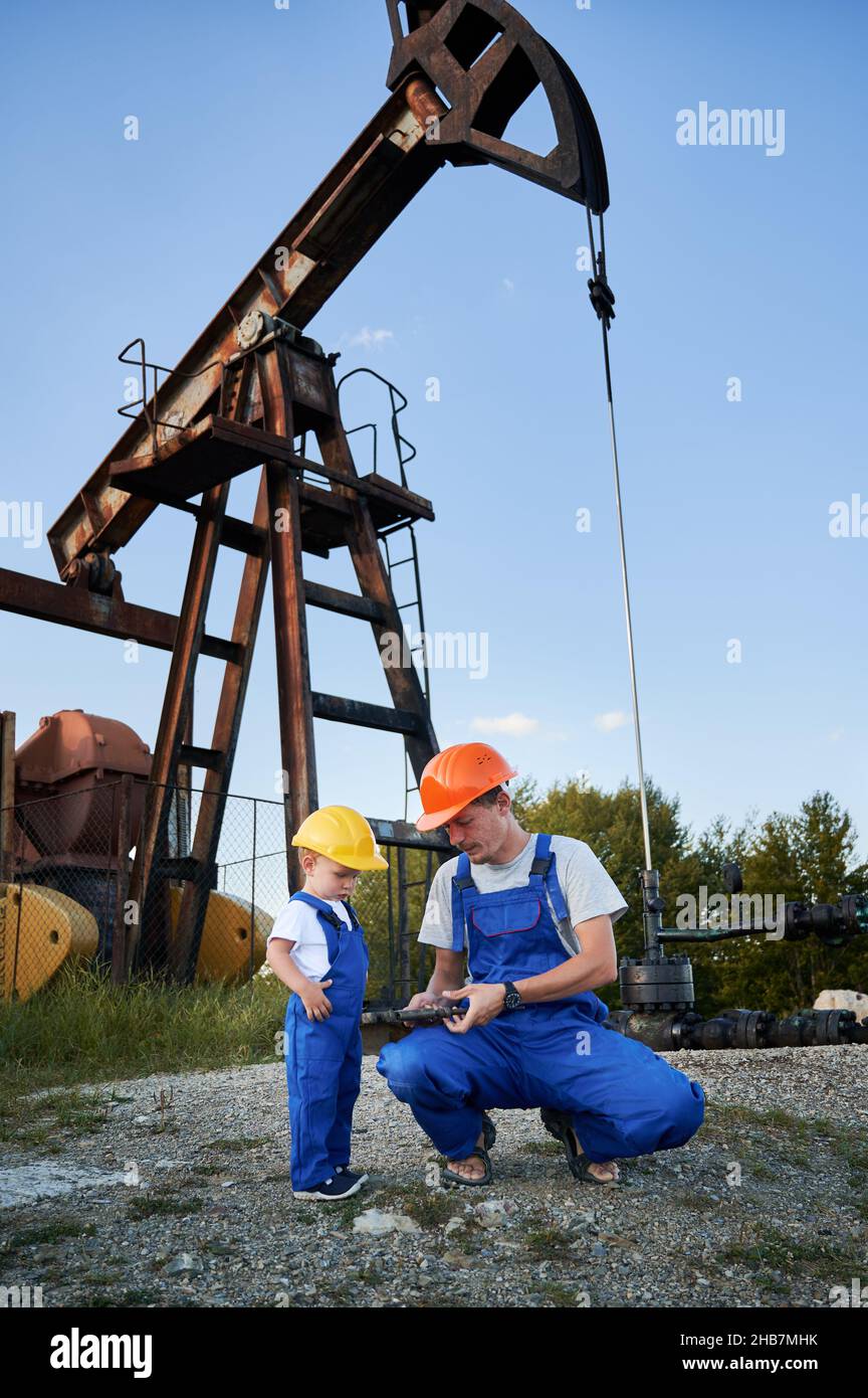 Engineer father introducing his son to work tool. Adult man and ...
