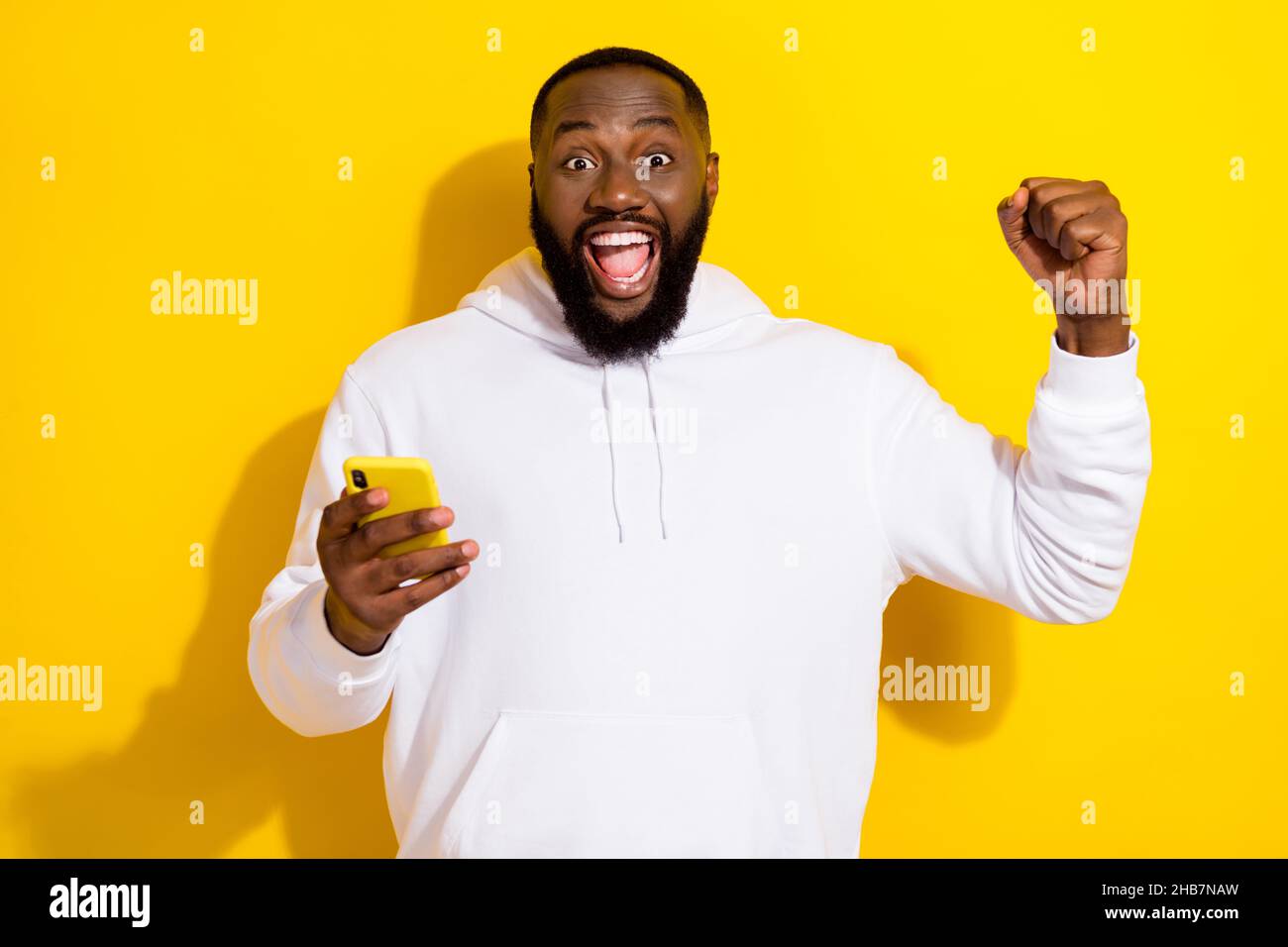 Photo of hooray millennial beard man hold telephone yell wear white ...