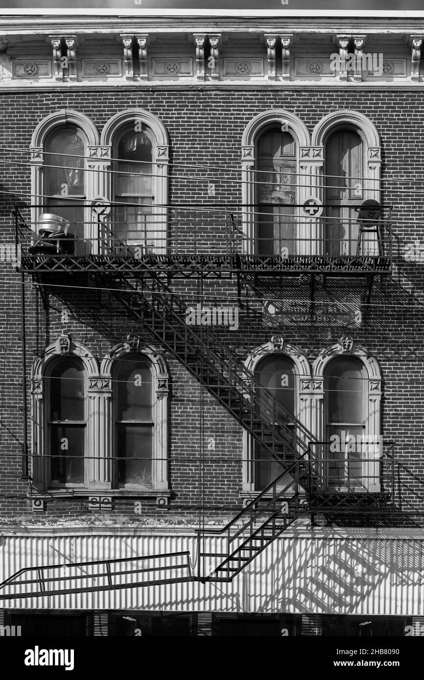 Vertical grayscale shot of the building facade with a fire escape Stock ...