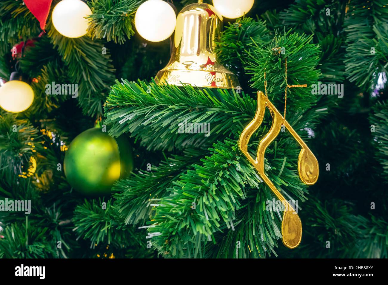Shiny treble clef ornament or gold music notes hanging on pine tree ...
