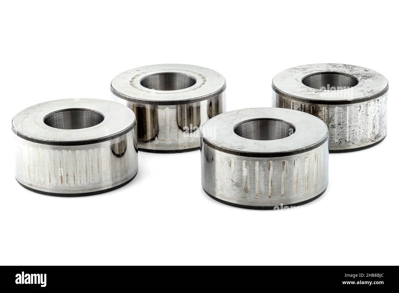 Photo of four turned bushings with a needle bearing dent, isolated on a ...