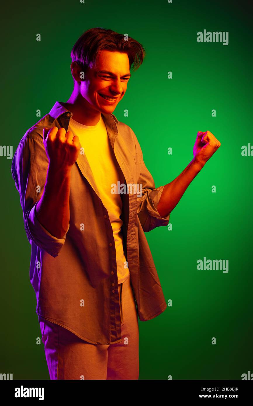 Full-length portrait of dancing young man, student isolated on green ...