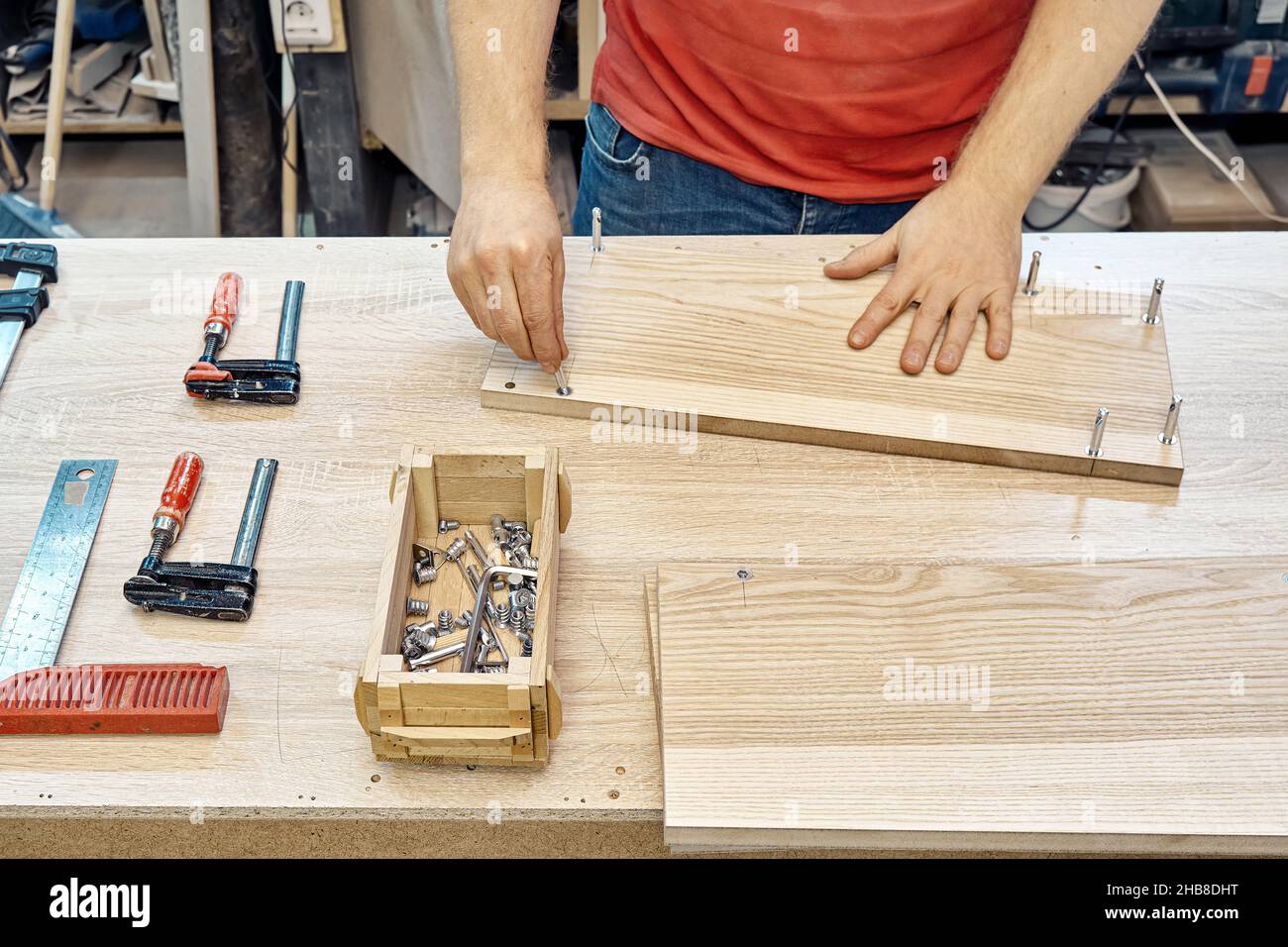 Carpenter assembles wooden furniture, twists the fittings into the ...