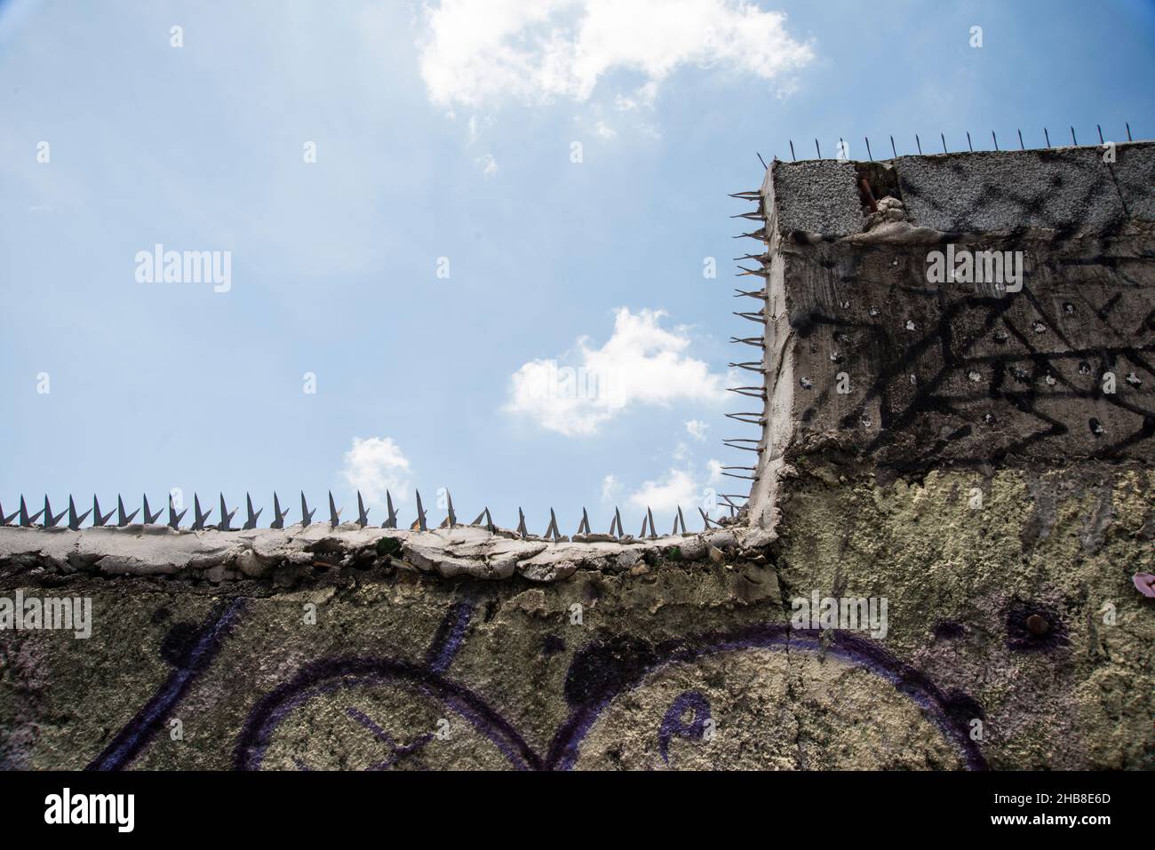 Wall with graffiti and spikes, background sky and clouds Stock Photo ...