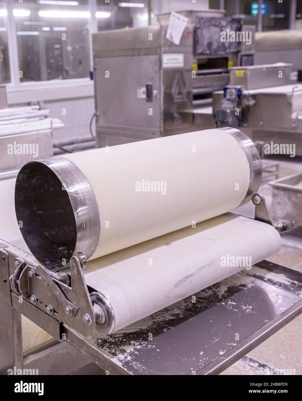 Baker making dough for pastry on dough sheeter. Dough rolling machine ...