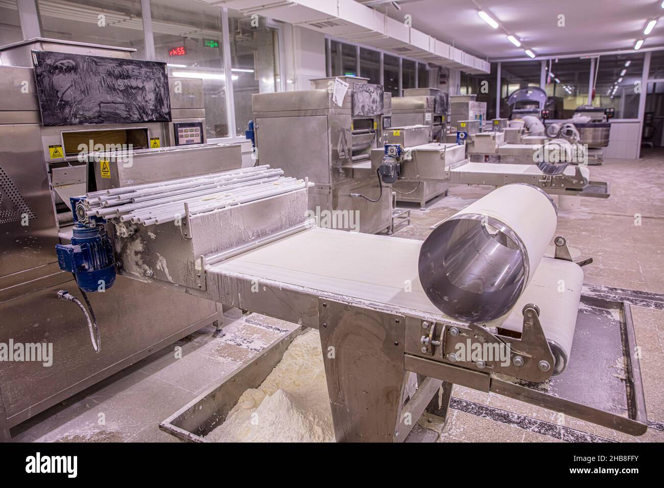 Baker making dough for pastry on dough sheeter. Dough rolling machine ...