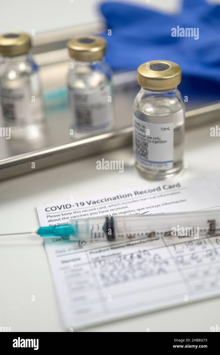 Syringe on Covid-19 vaccination record card and vials on tray Stock ...