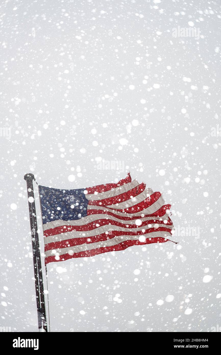 Torn American flag on flag pole with falling snow Stock Photo - Alamy