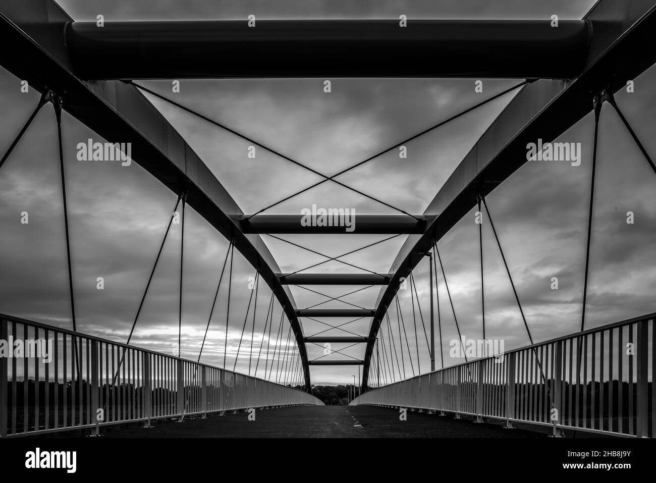 Grayscale vanishing point shot of a modern partially covered bridge ...