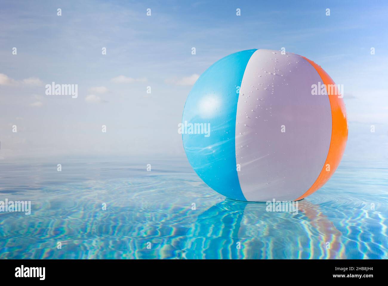 Beach ball floating on calm water surface Stock Photo - Alamy