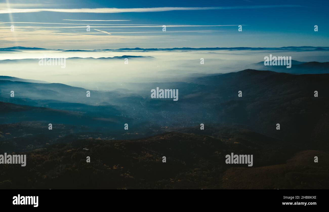 Mountain view with mist over them. Stunning view with blue sky, bright ...