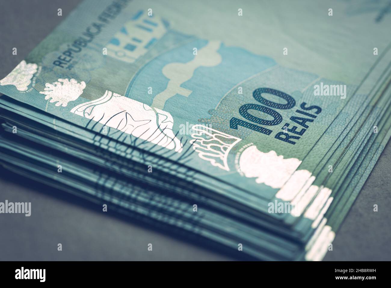 Large bundle of Brazilian money, 100 reais banknotes, gray background ...