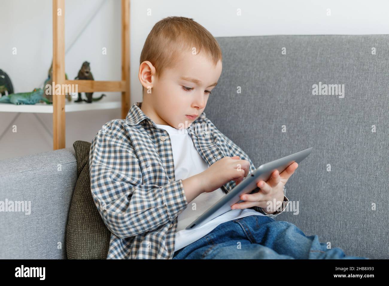 Boy without parental control wasting time playing games. Kid having fun ...