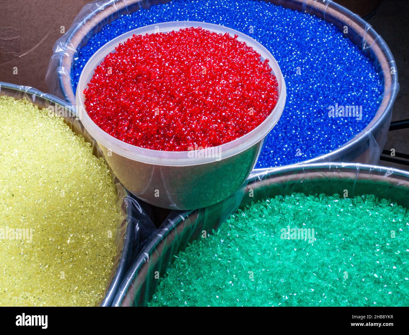 bins or barrels of Colorful plastic beads. Microplastics. Industrial ...