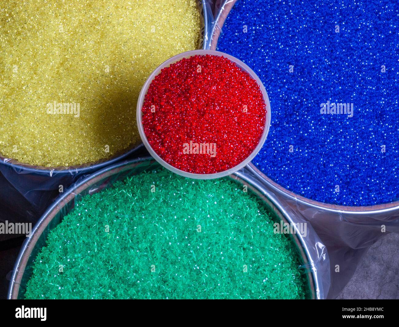 bins or barrels of Colorful plastic beads. Microplastics. Industrial ...