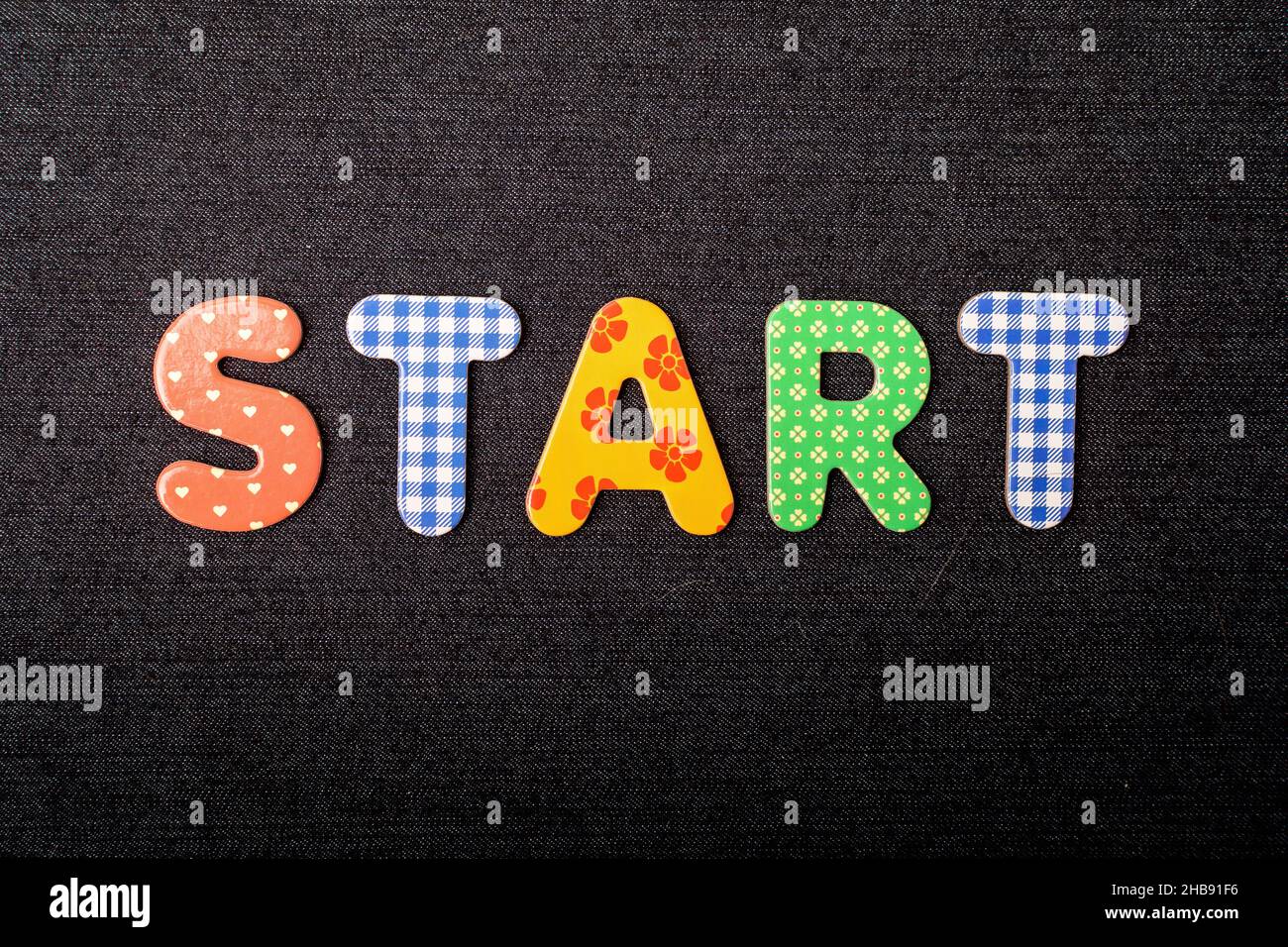 Card with Start word made from mixed vivid colored wooden letters on a ...