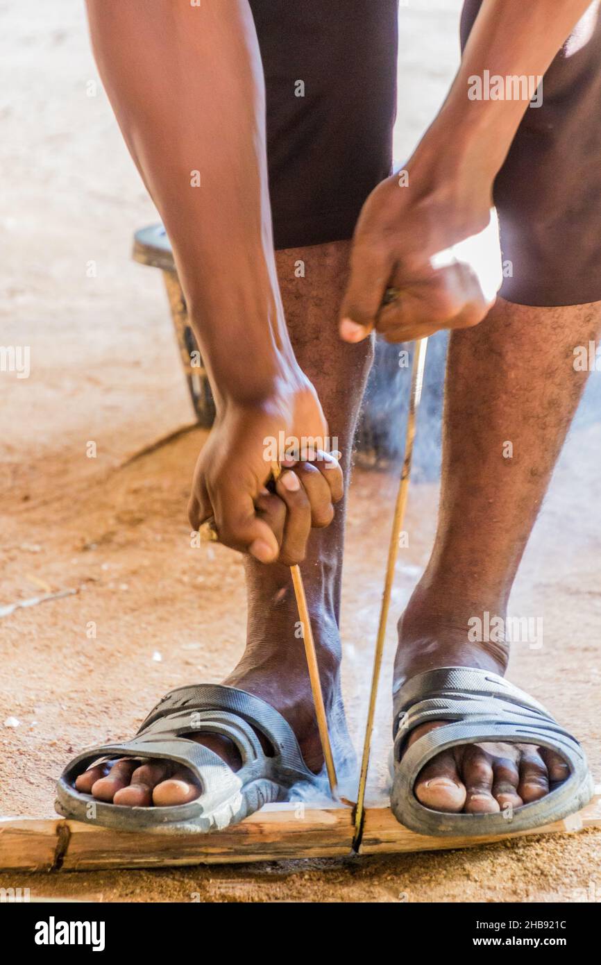 Indigenous man making fire in his village in Taman Negara national park ...