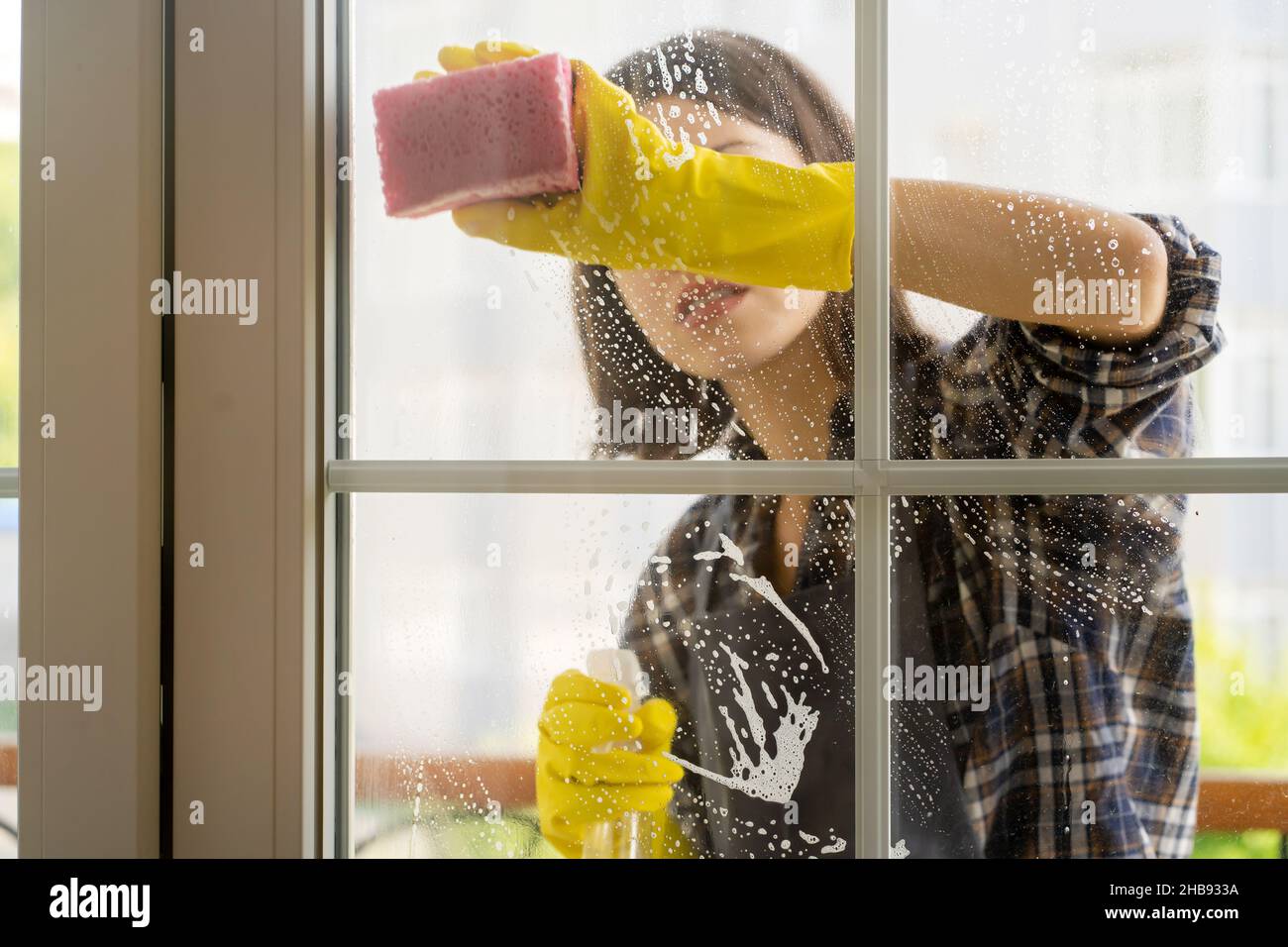 Woman washes the windows with a detergent Stock Photo - Alamy