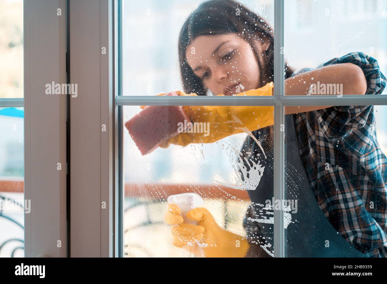 Woman washes the windows with a detergent Stock Photo - Alamy