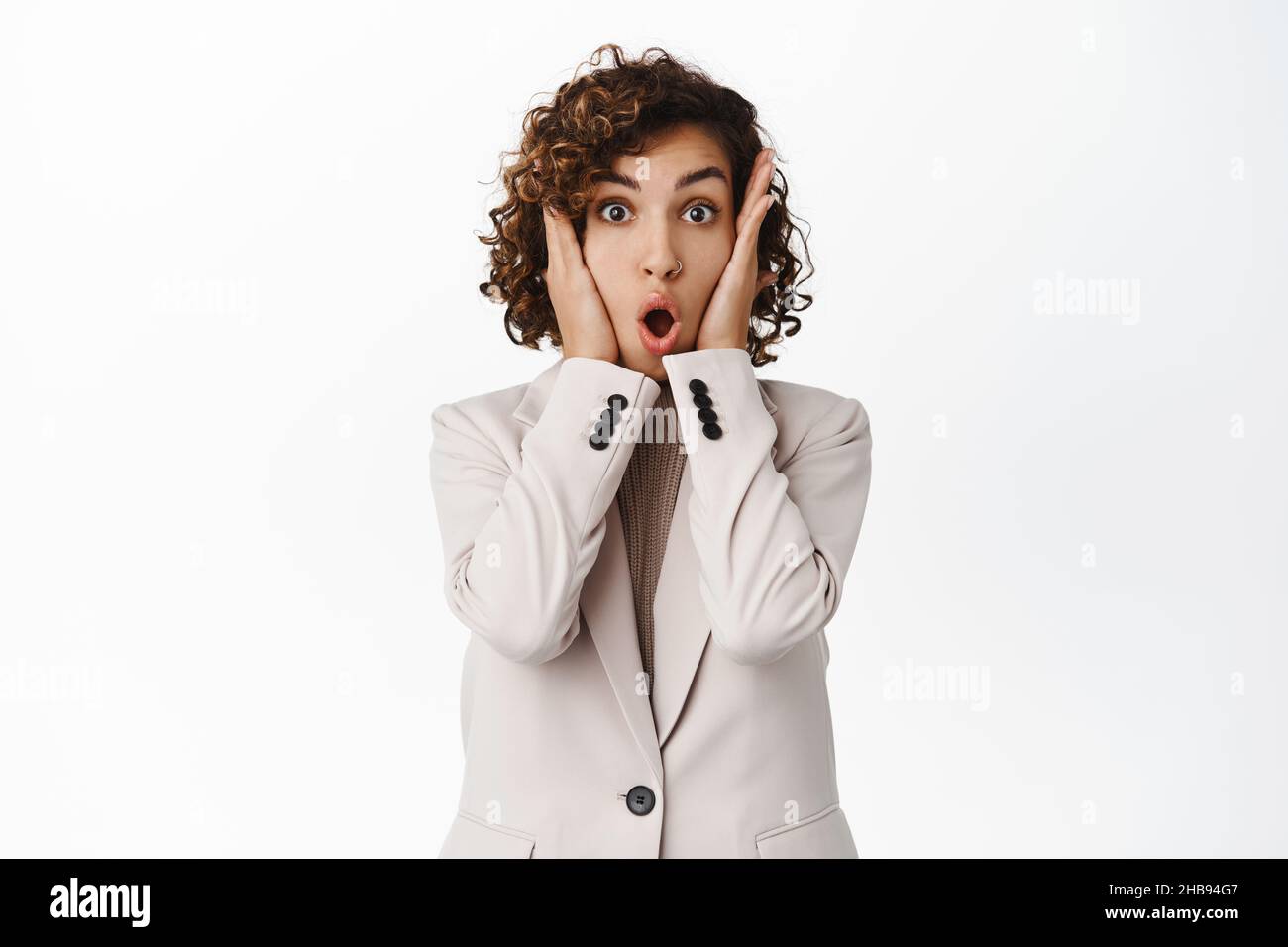 Shocked and amazed young corporate woman looking speechless, gasping ...