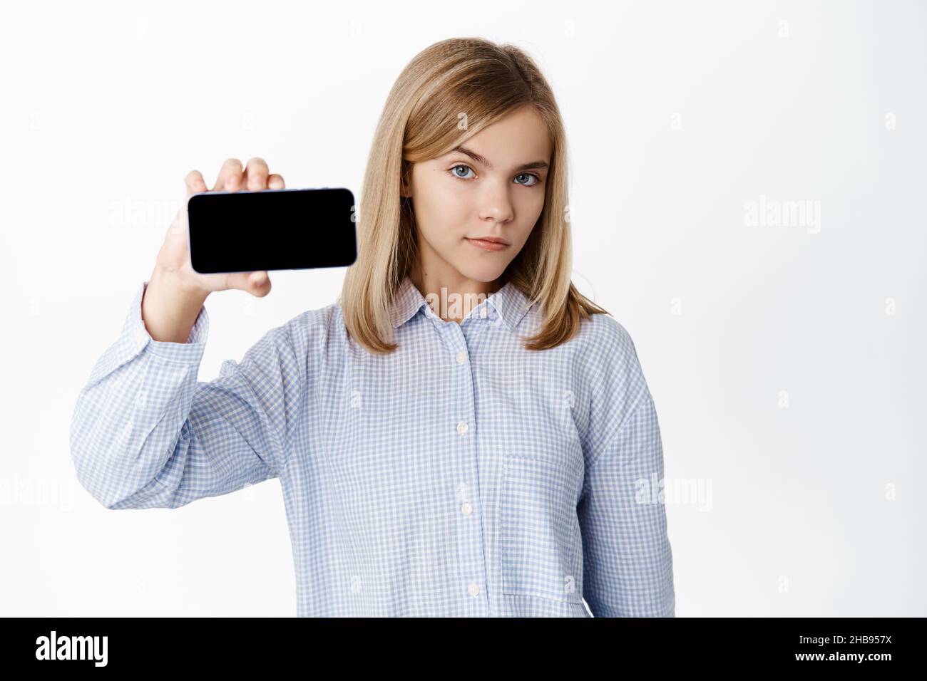 Smart kid, cute blond girl showing horizontal smartphone screen, mobile ...
