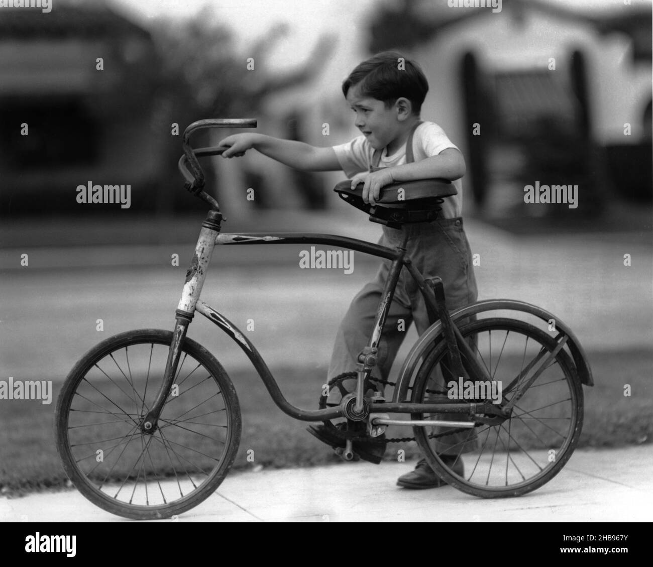 Young lad about to get on his 2-wheeled bicycle. Circia 1945 Stock ...