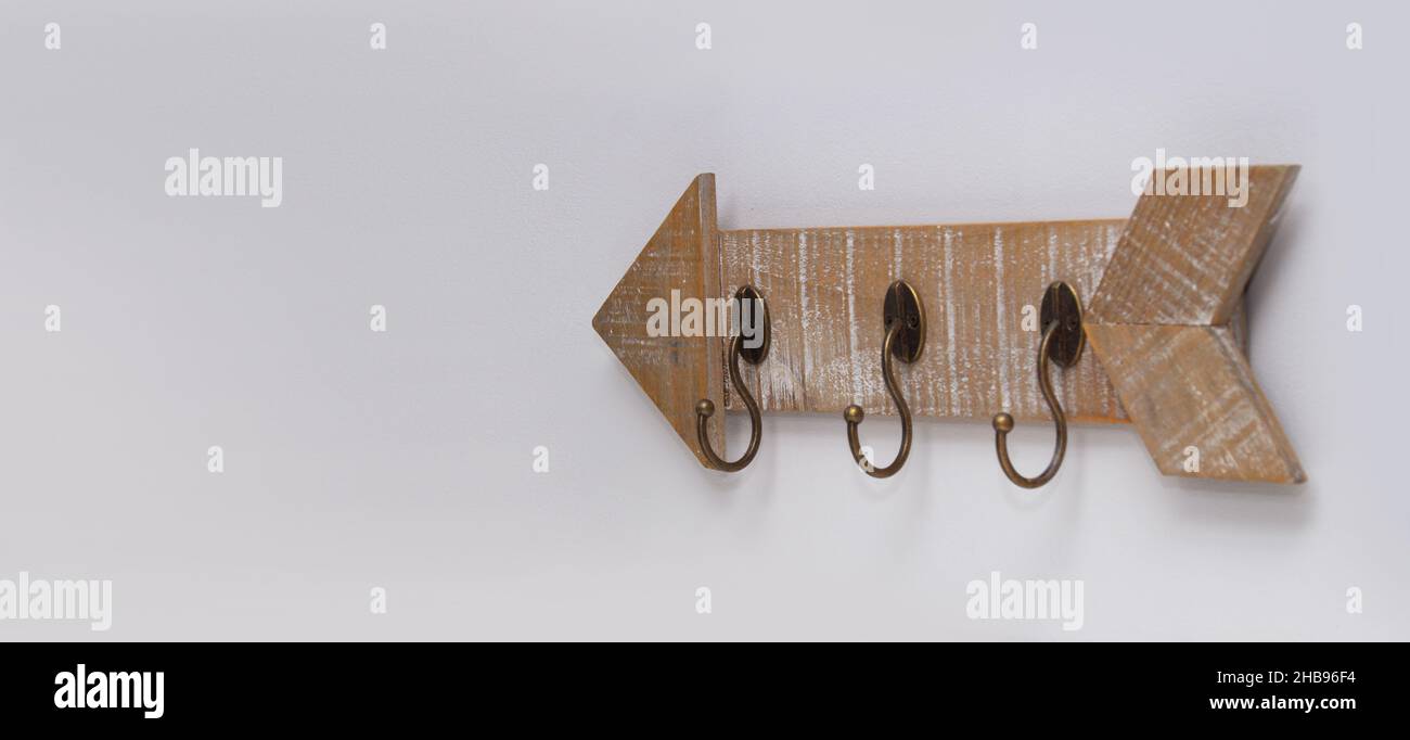 An arrow-shaped hanger for clothes or keys is located on the wall ...