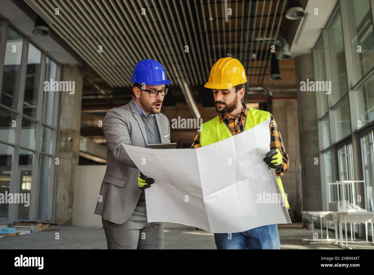 Construction worker holding blueprints and listening to suggestions ...