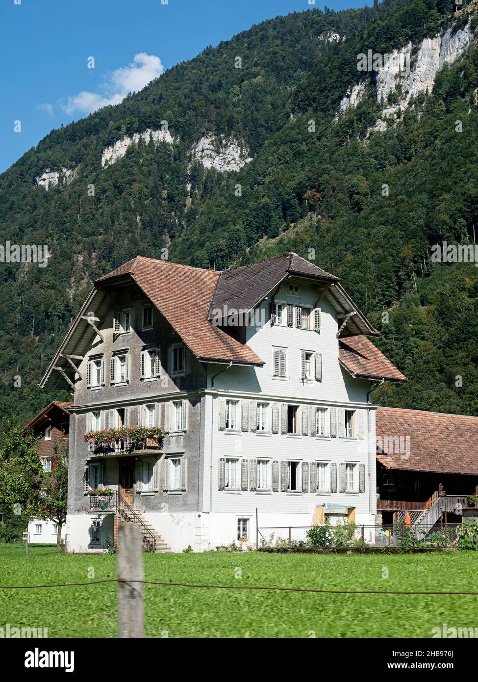 Typical old swiss building at the bottom of a mountain in summer time ...