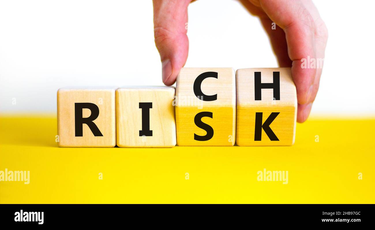 Take a risk and getting rich symbol. Businessman turns wooden cubes and ...